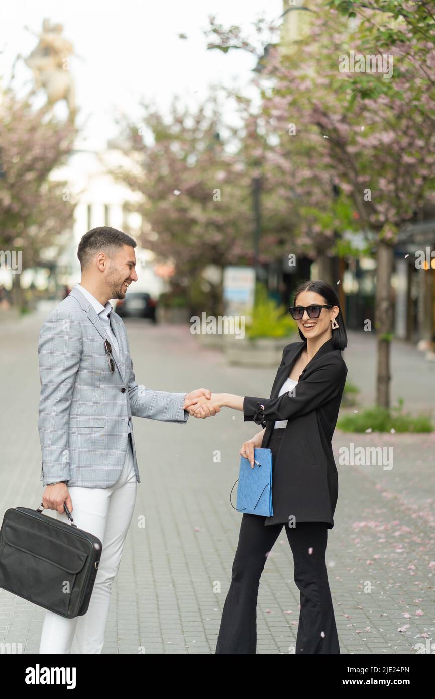 Two business partners are smiling while making a deal Stock Photo - Alamy