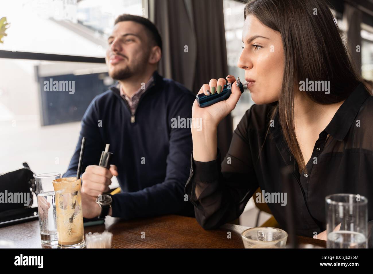 Amazing and attractive young business people are smoking cigarettes and ...
