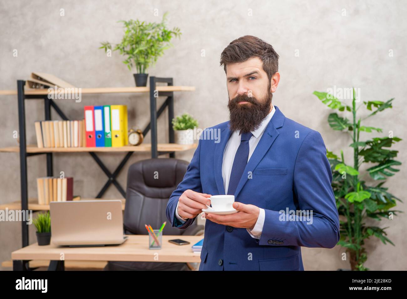 confident bearded businessman drinking coffee in the office with copy ...