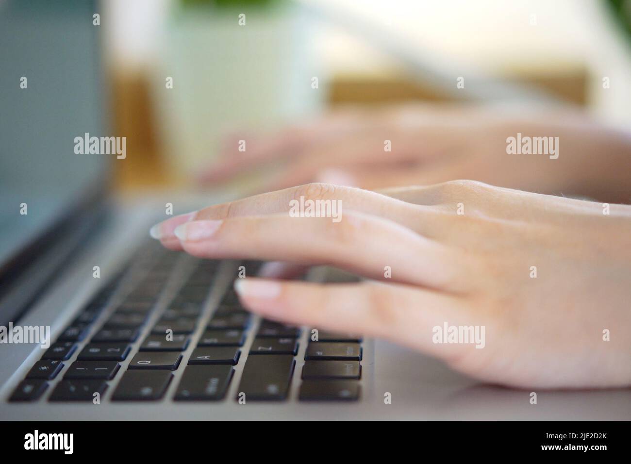 Female hands typing text messages on a laptop keyboard close-up. Busy ...