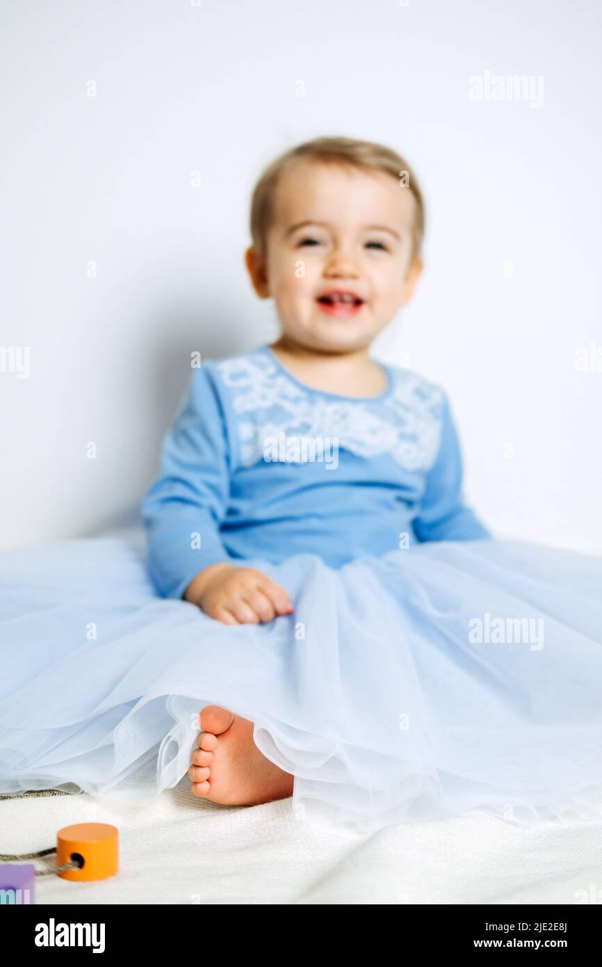 Cute baby girl in blue princess dress playing with toys at home. Kids ...