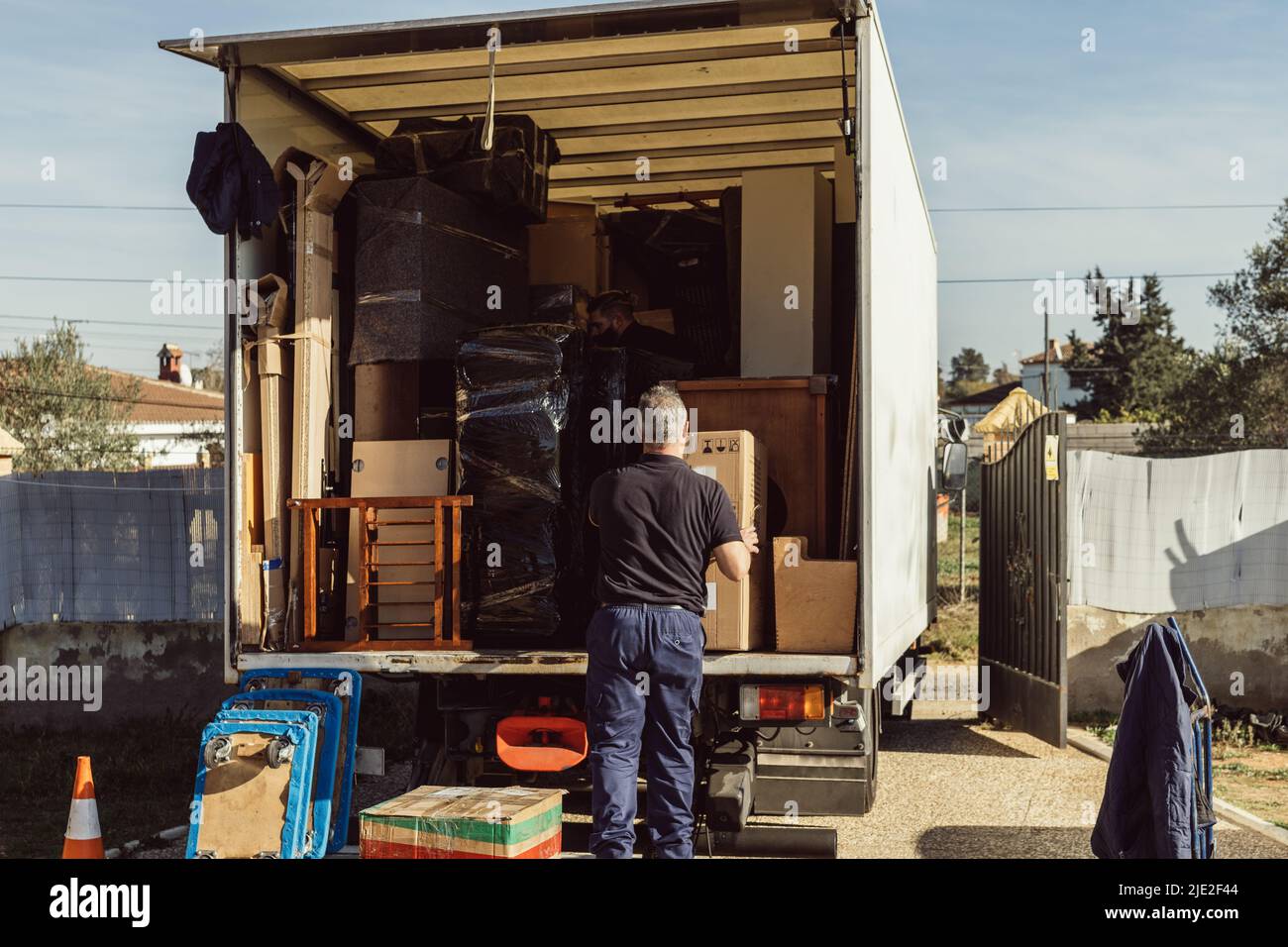 older worker loading cardboard boxes onto moving truck Stock Photo - Alamy