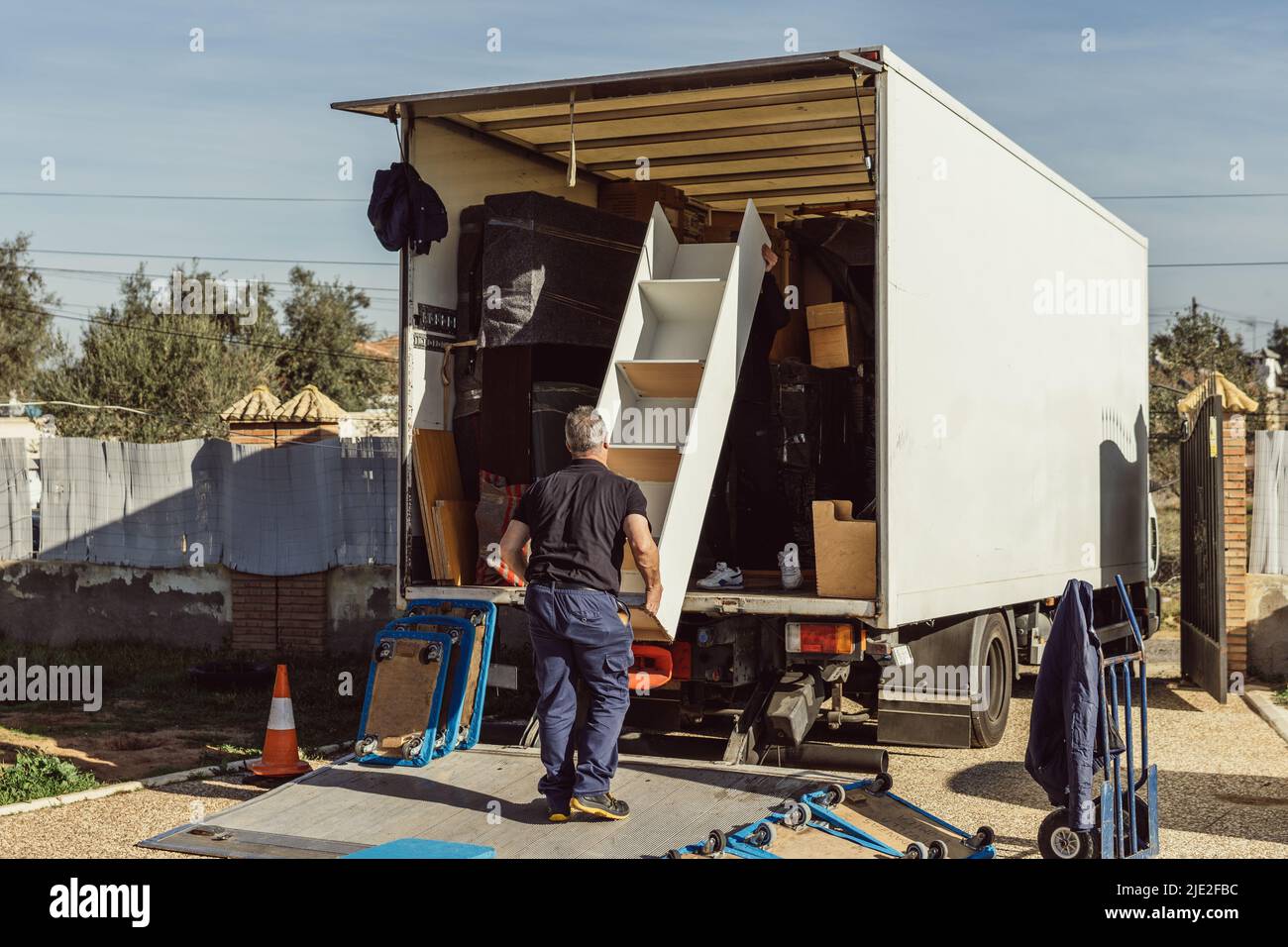 gray-haired man loading furniture onto a moving truck Stock Photo - Alamy