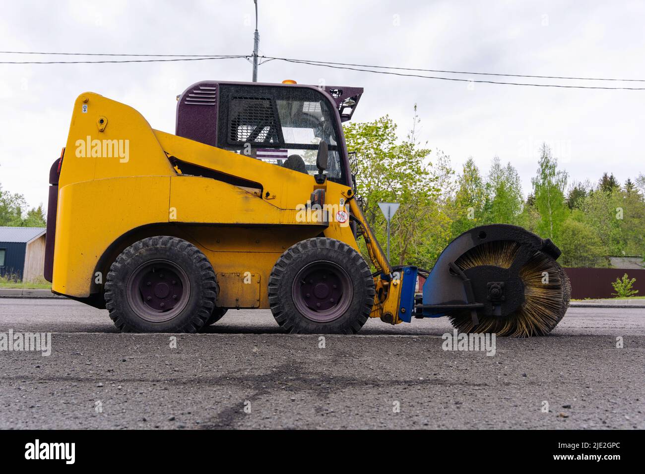 Cleaning of garbage from the road. a rotating mechanical machine brush ...