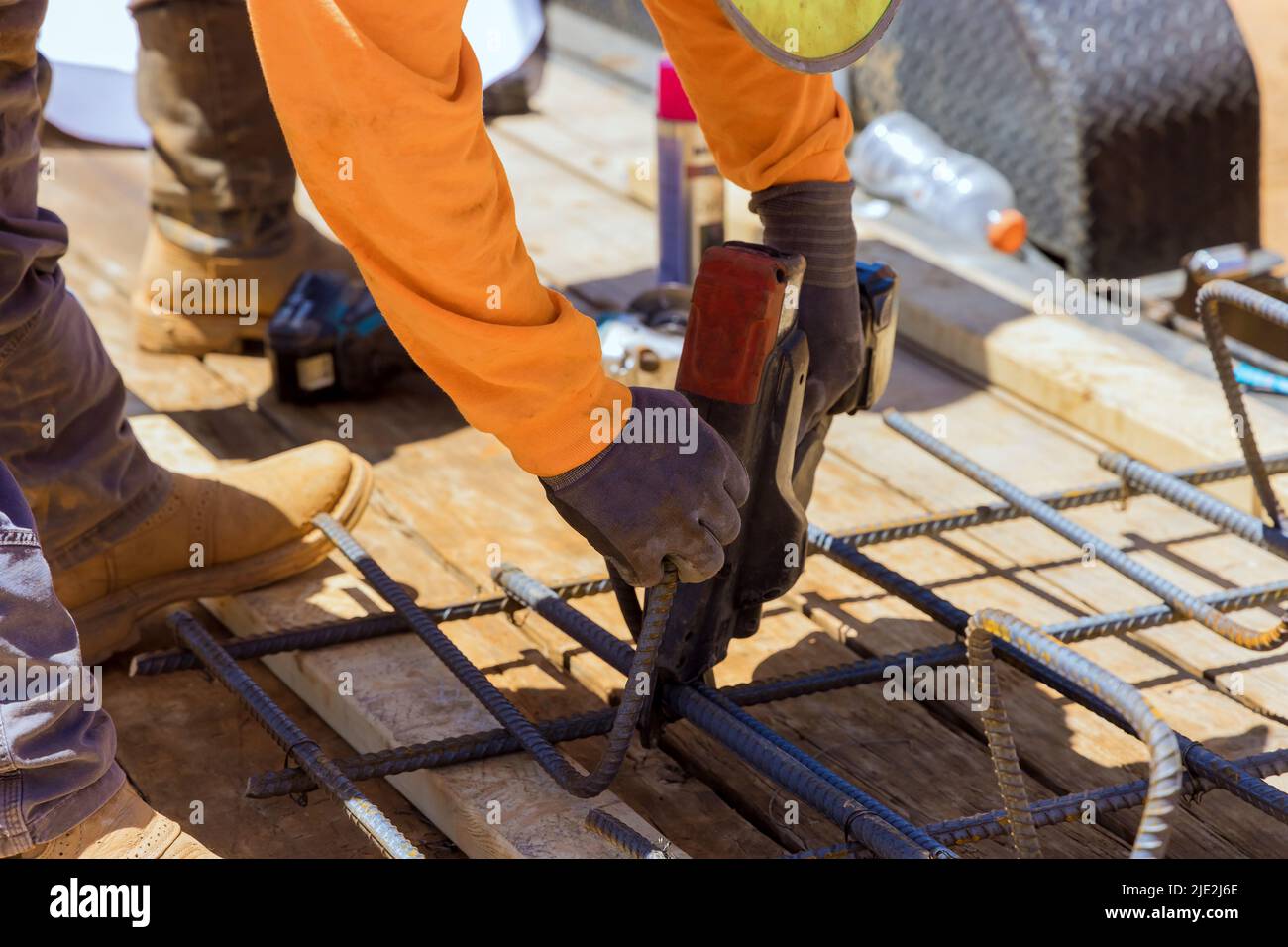 Construction worker hands securing steel bars with wire rods for cement ...