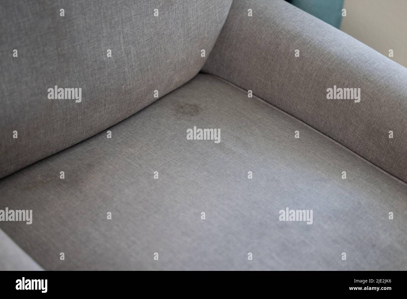 Close up view of a stained upholstered living room chair that needs to ...