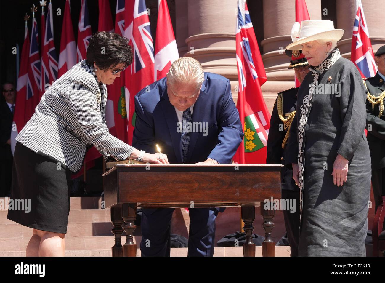 Premier Doug Ford signs as he takes his oath at the swearing-in ...