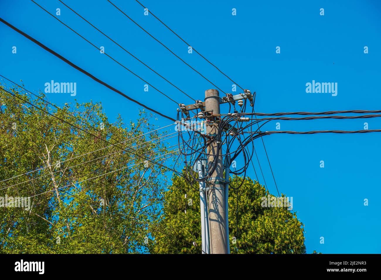Electric pole power lines outgoing electric wires againts on cloud blue ...
