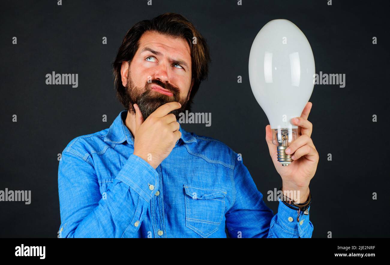 Birth of ideas. Pensive man with light bulb. Thoughtful bearded guy ...