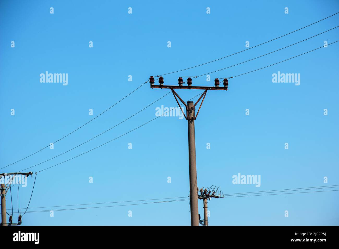 Electric pole power lines outgoing electric wires againts on cloud blue ...