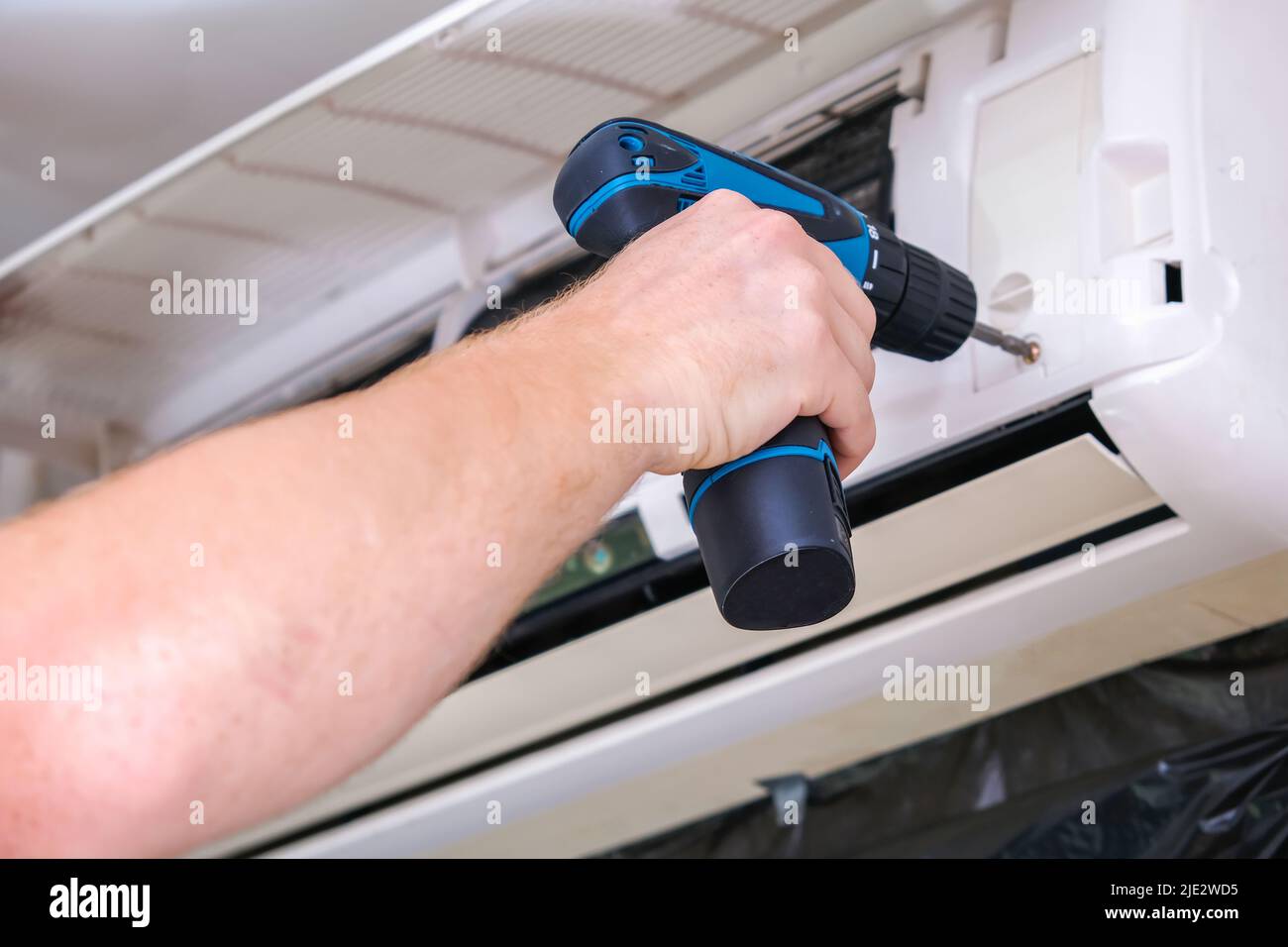A man disassembles an air conditioner for repair and cleaning. Split ...