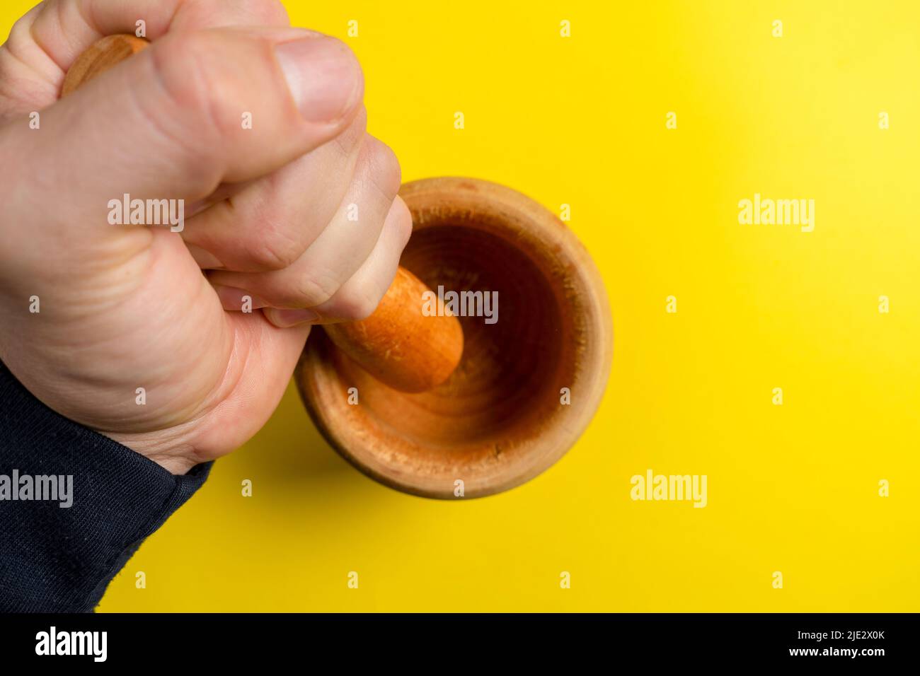Man's hand with a wooden kitchen mortar prepared to make a sauce Stock ...
