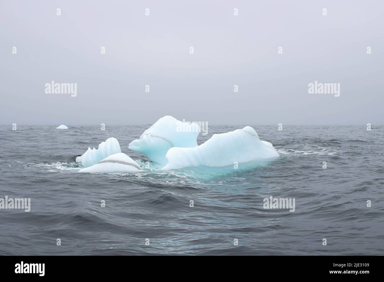 Wave crashing against small iceberg bit floating in sea Stock Photo - Alamy