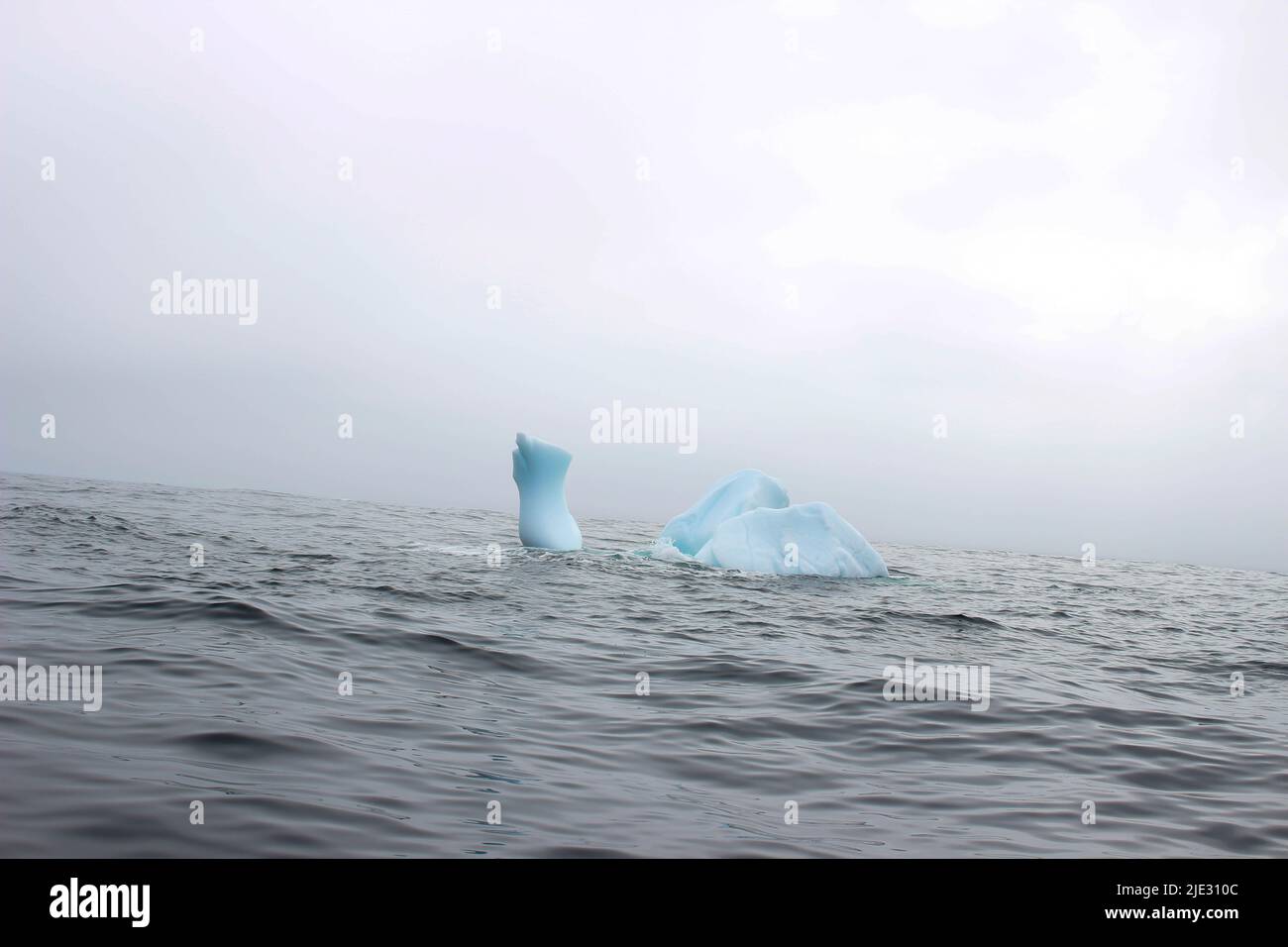 Wave crashing against small iceberg bit floating in sea Stock Photo - Alamy