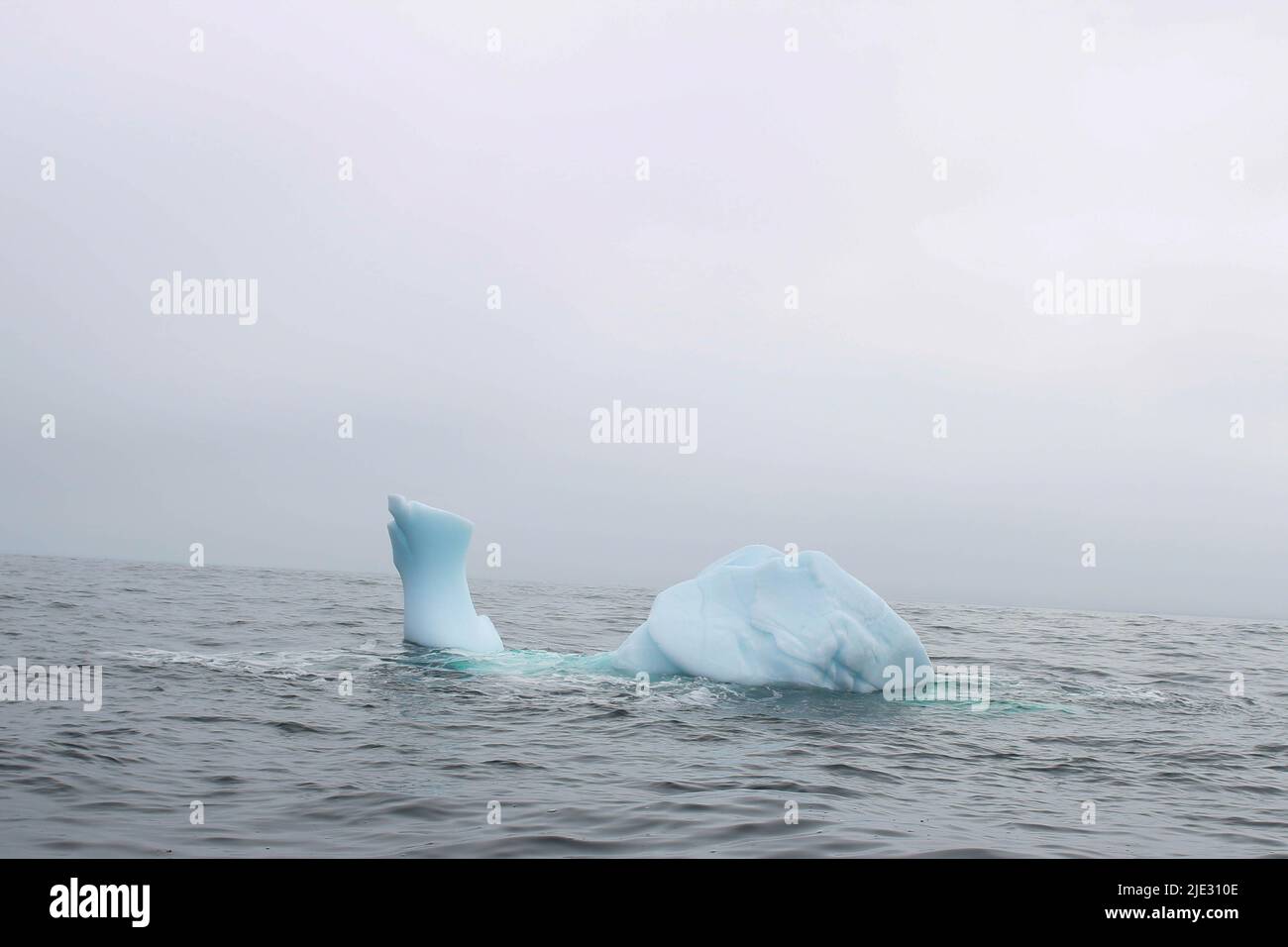 Wave crashing against small iceberg bit floating in sea Stock Photo - Alamy