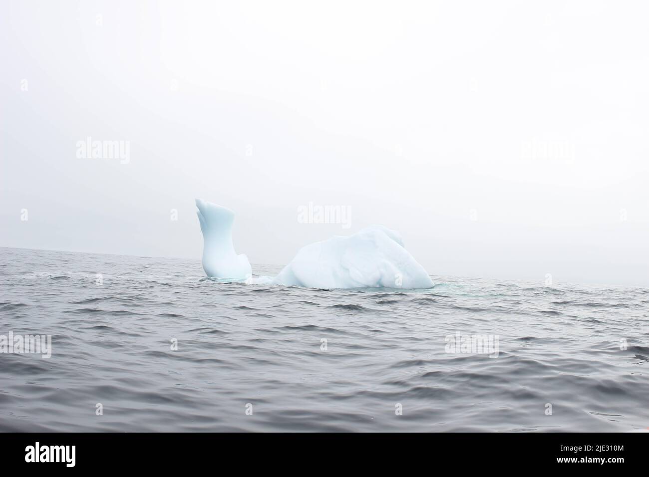 Wave crashing against small iceberg bit floating in sea Stock Photo - Alamy