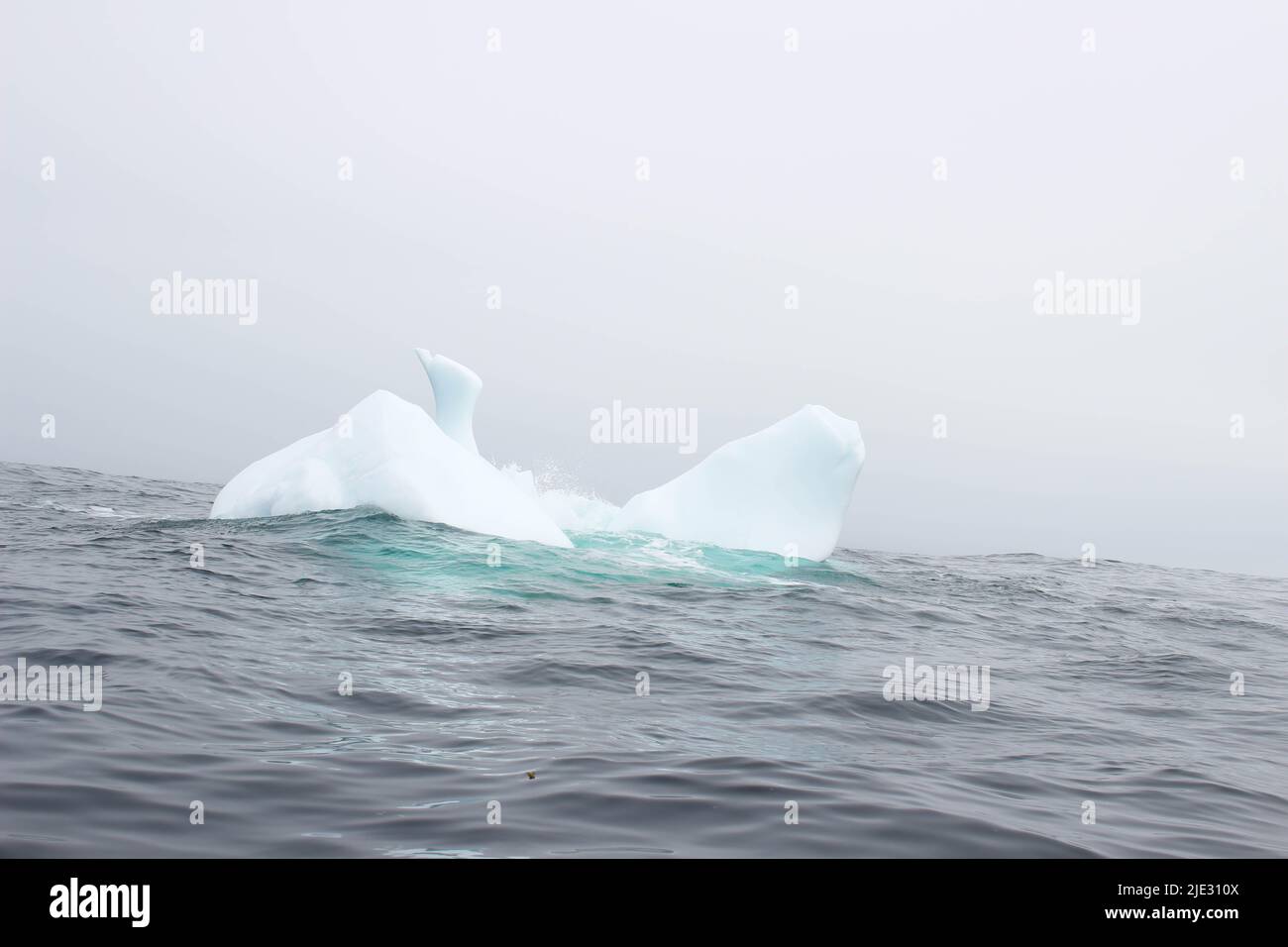Wave crashing against small iceberg bit floating in sea Stock Photo - Alamy