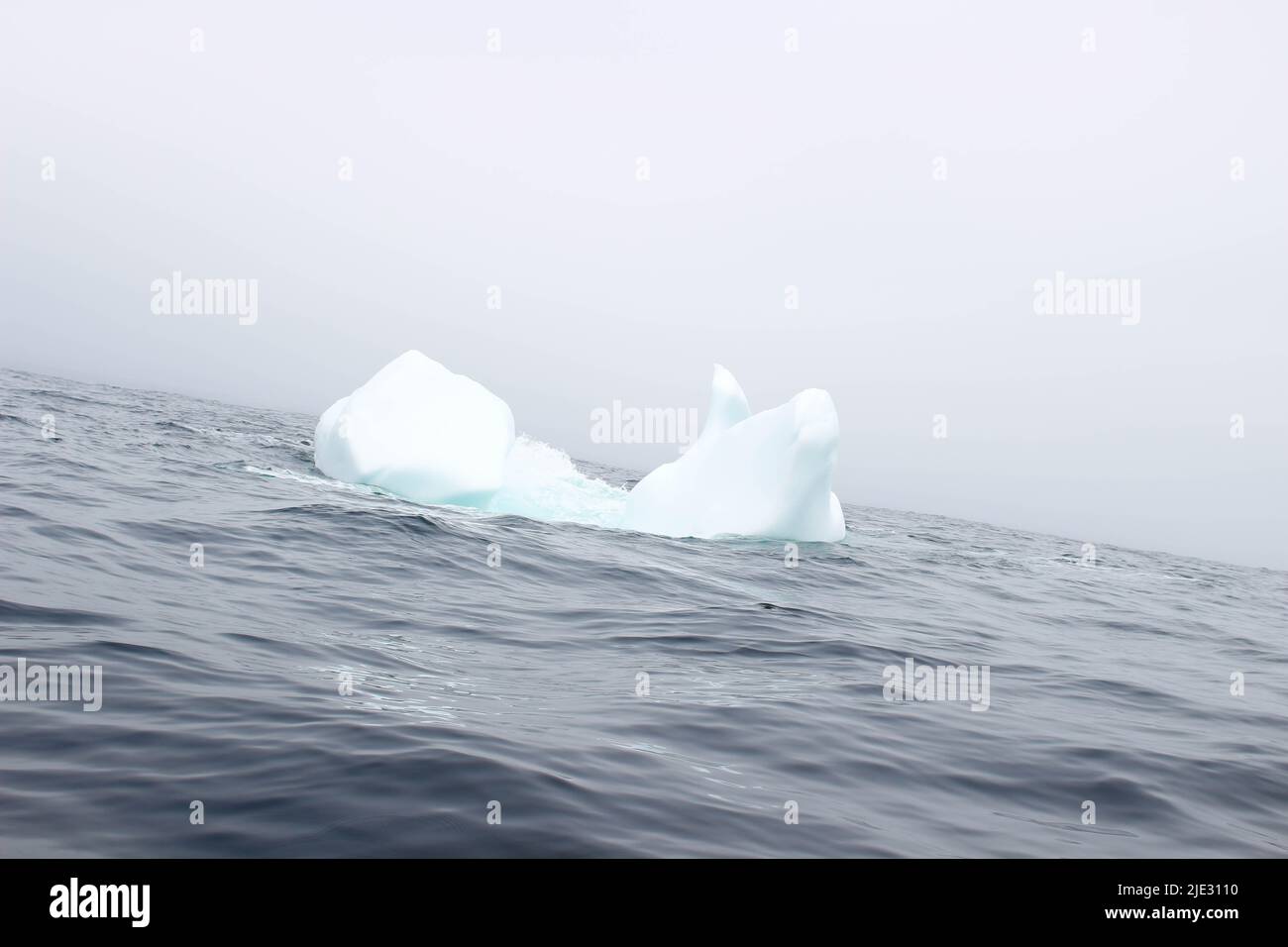 Wave crashing against small iceberg bit floating in sea Stock Photo - Alamy