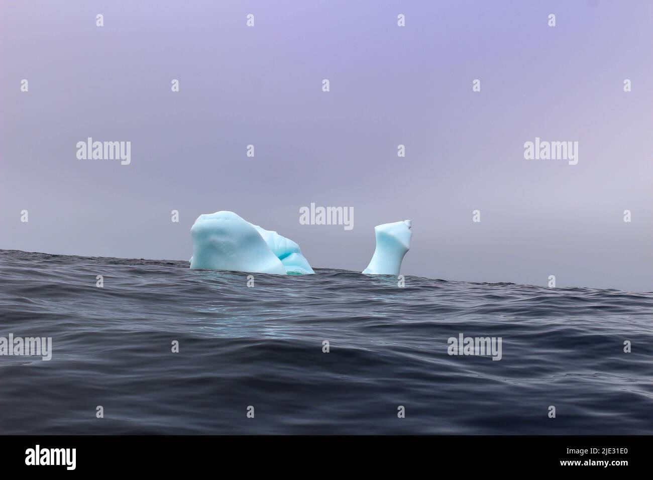 Wave crashing against small iceberg bit floating in sea Stock Photo - Alamy