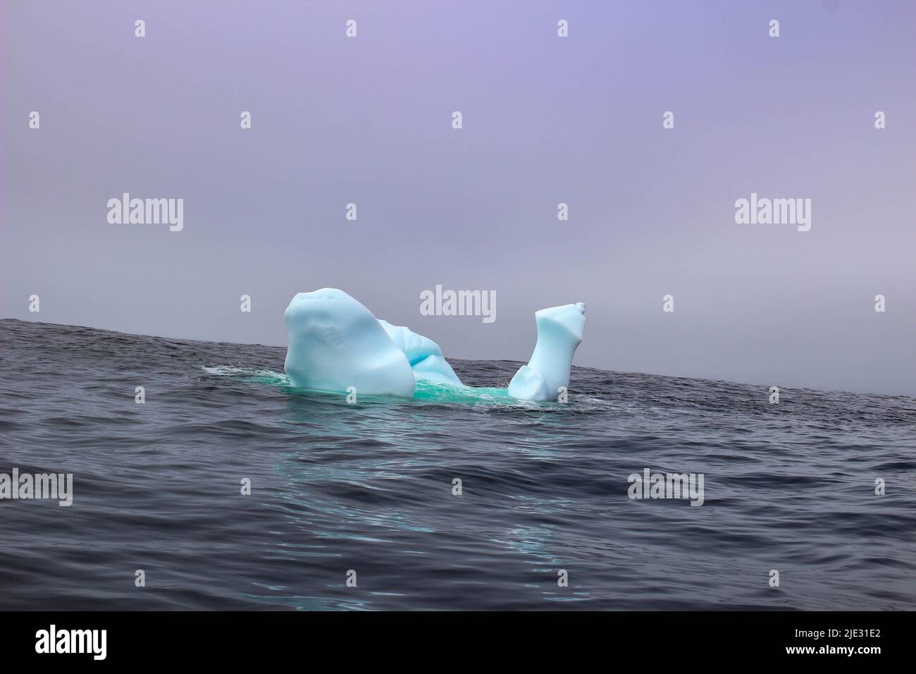 Wave crashing against small iceberg bit floating in sea Stock Photo - Alamy