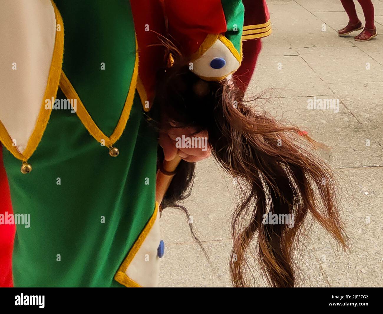 detail of the colorful harlequin dancer dressed with a ponytailed stick ...
