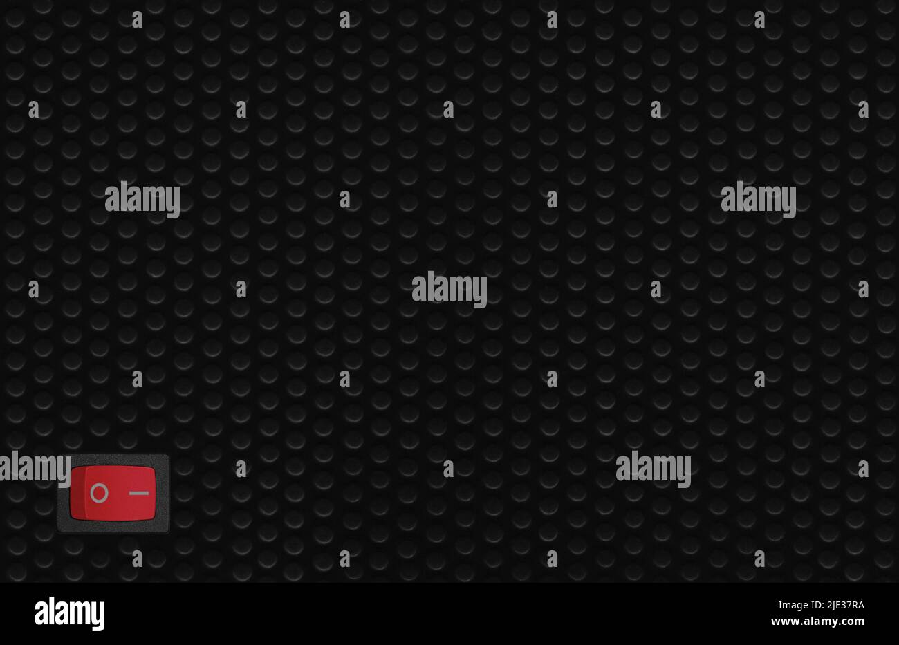 Red rectangle rocker power switch in on position, black abstract dot ...