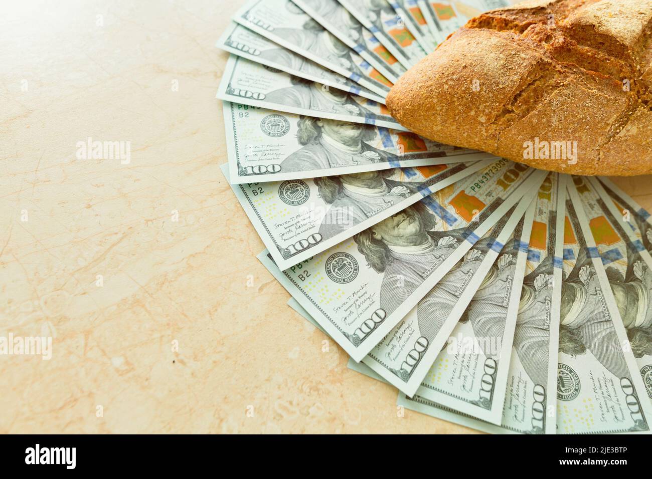 Bread on a fan of banknotes, 100 dollar bills, copyspace. Wealth ...
