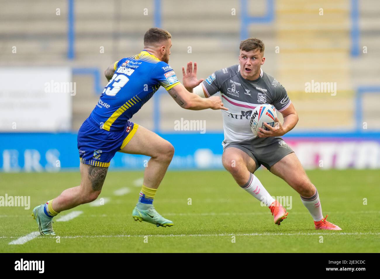 Connor Wynne #23 of Hull FC hands off Connor Wrench #23 of Warrington ...