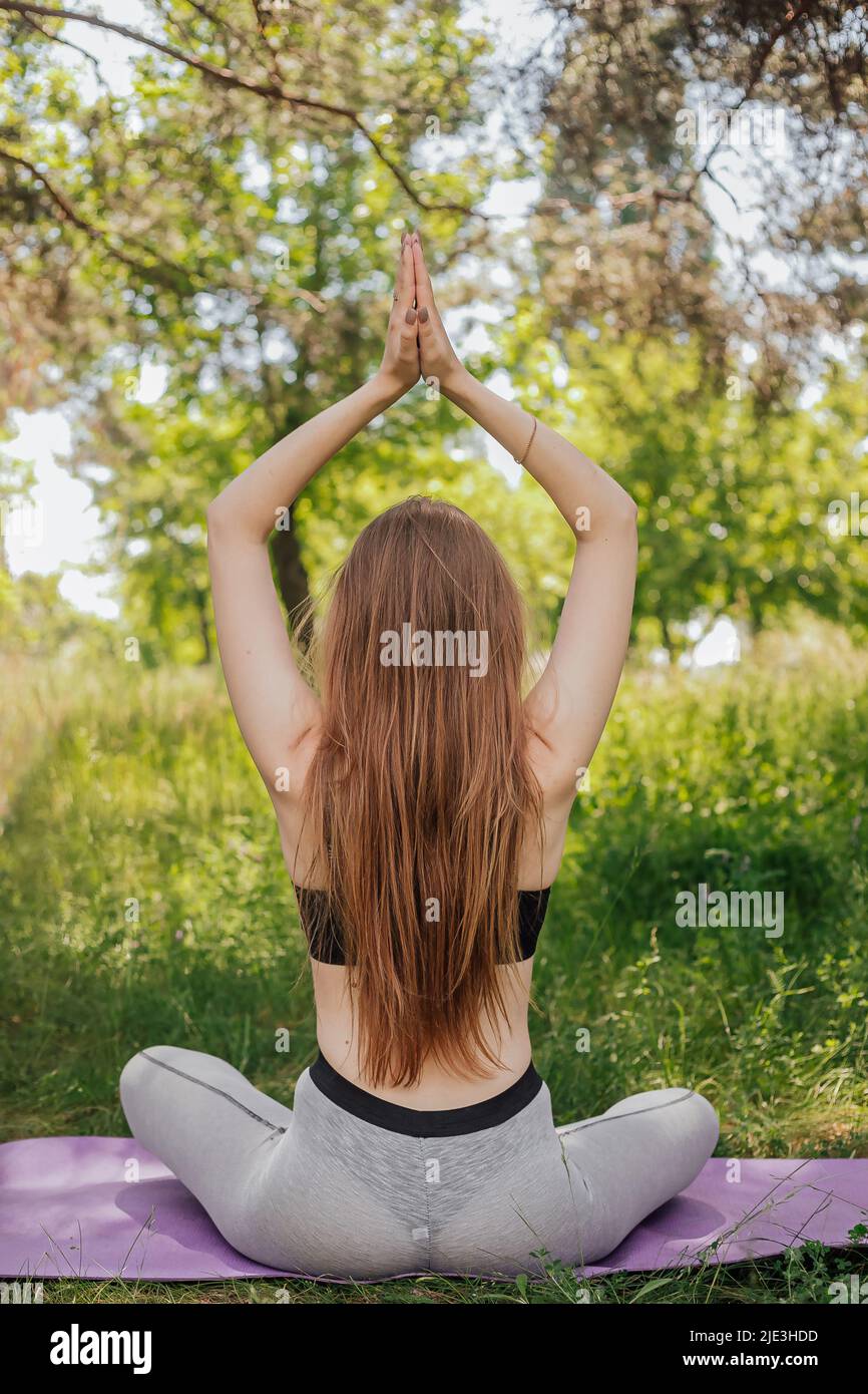 Yoga woman on green grass girl relaxes in the field. Yoga woman in ...