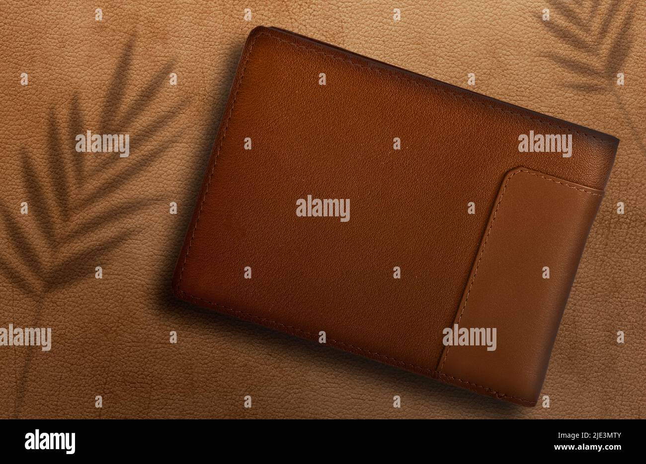 Logo mockup on leather brown wallet On a brown background with shadows ...