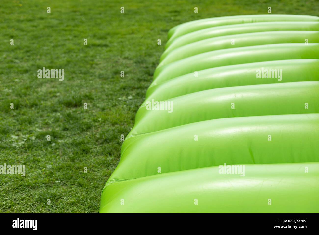 Green inflatable trampoline. Obstacle course. Details of amusement park ...