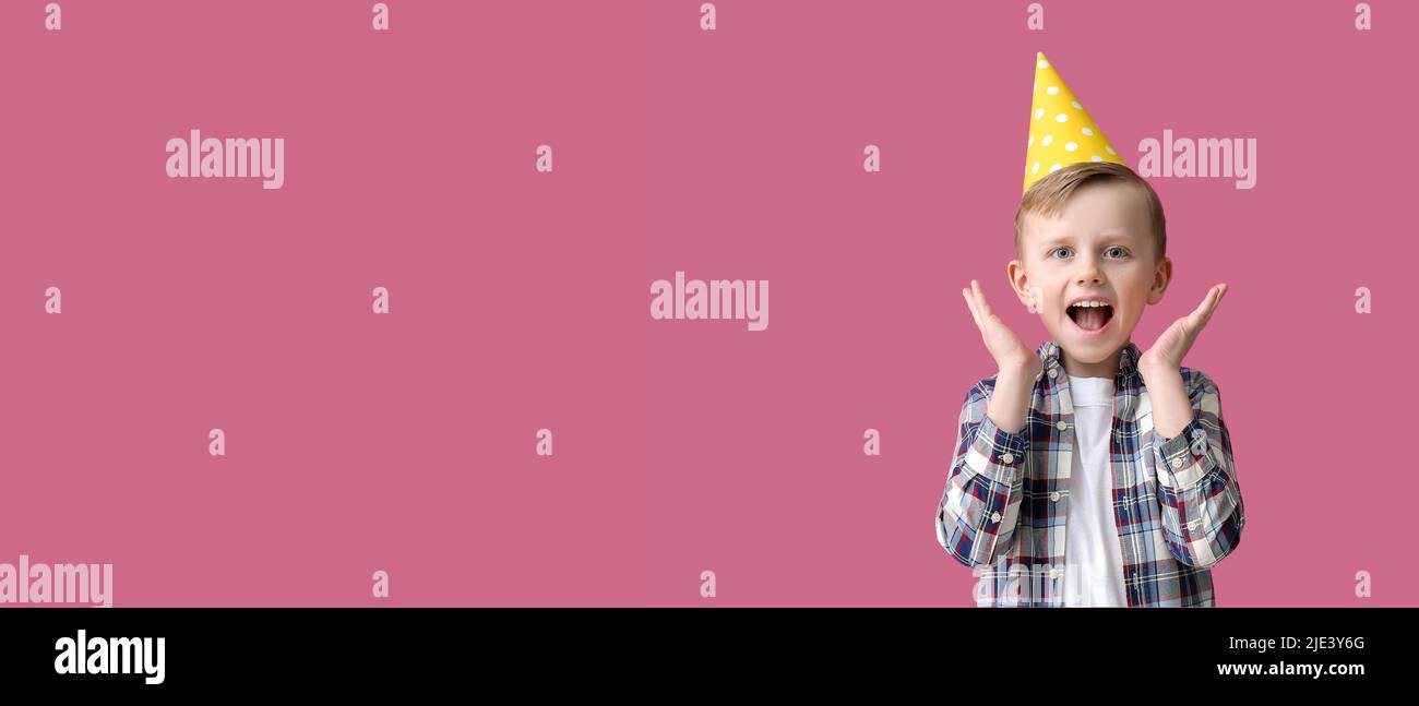 Surprised little boy in Birthday cap on pink background with space for ...