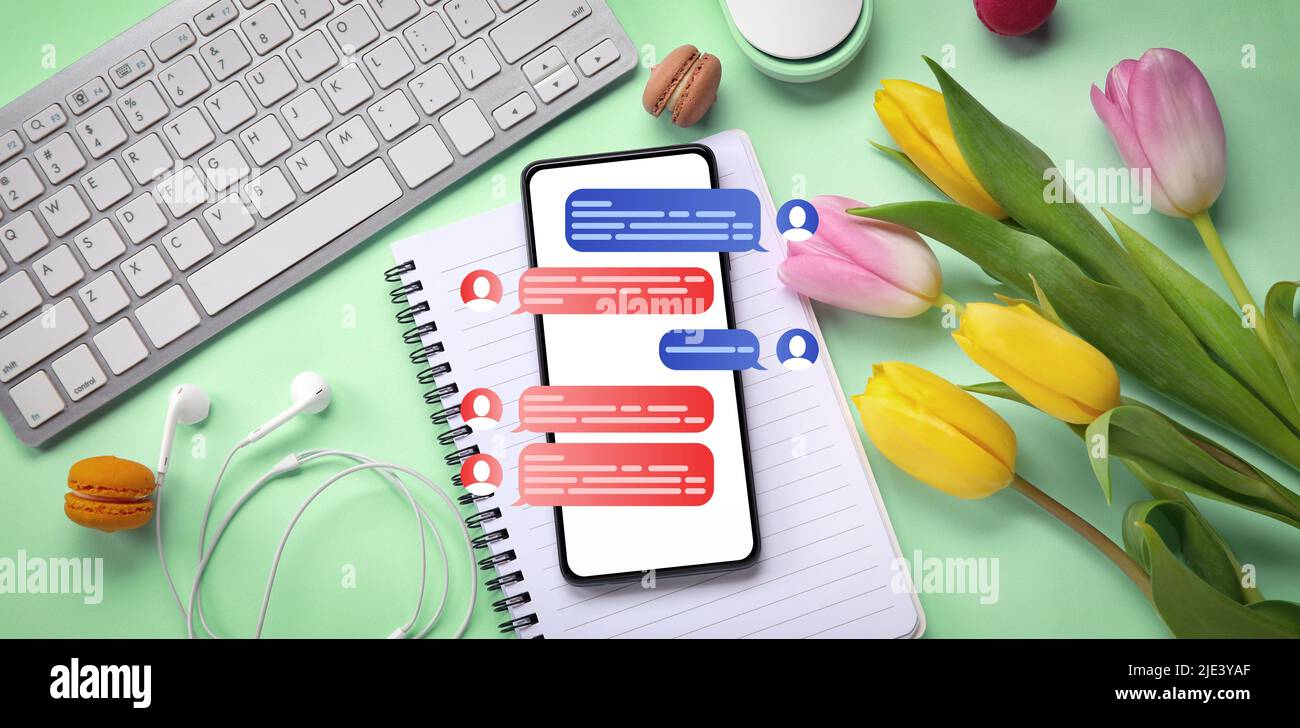 Mobile phone with notebook, computer keyboard and tulip flowers on ...