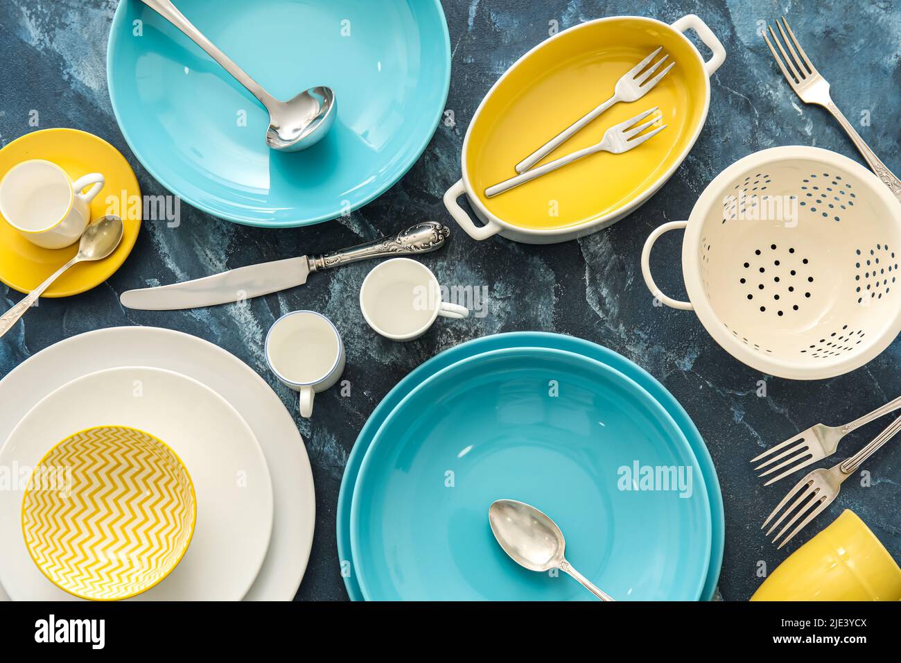 Colorful dinnerware and kitchen utensils on blue background Stock Photo ...