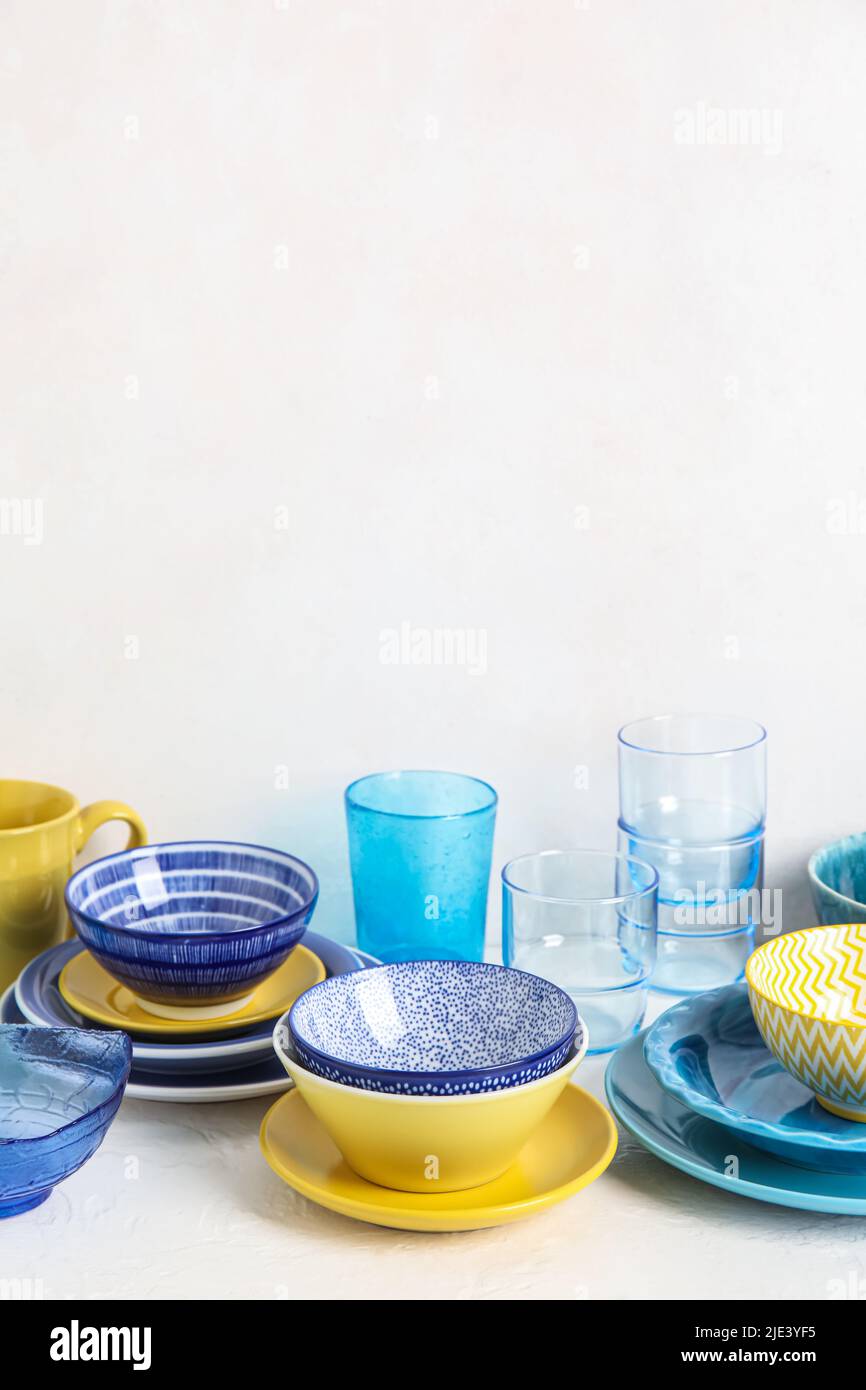 Set of color dinnerware on light background Stock Photo - Alamy