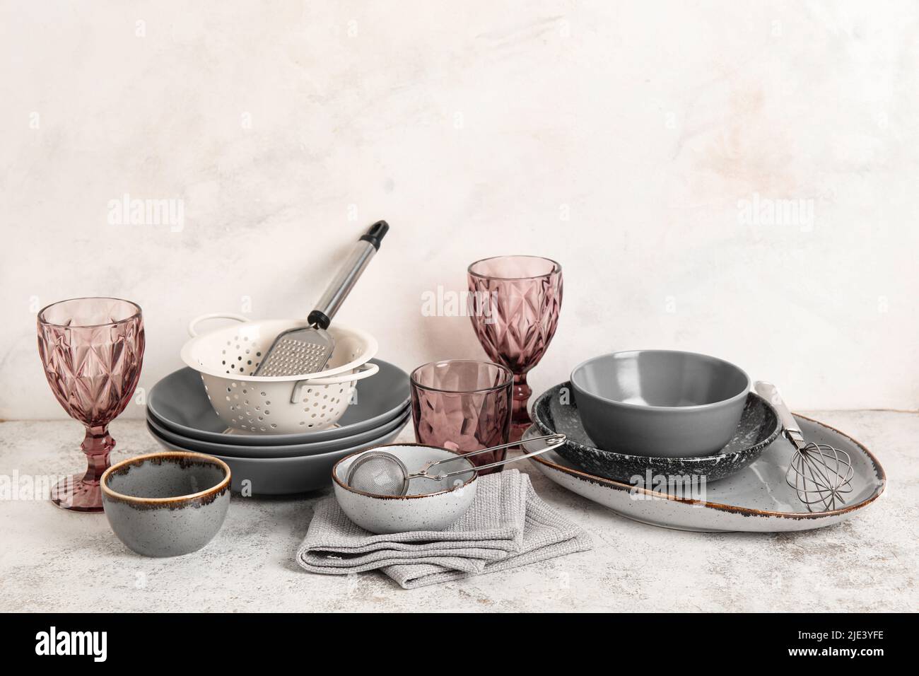 Set of clean dinnerware and kitchen utensils on light background Stock ...