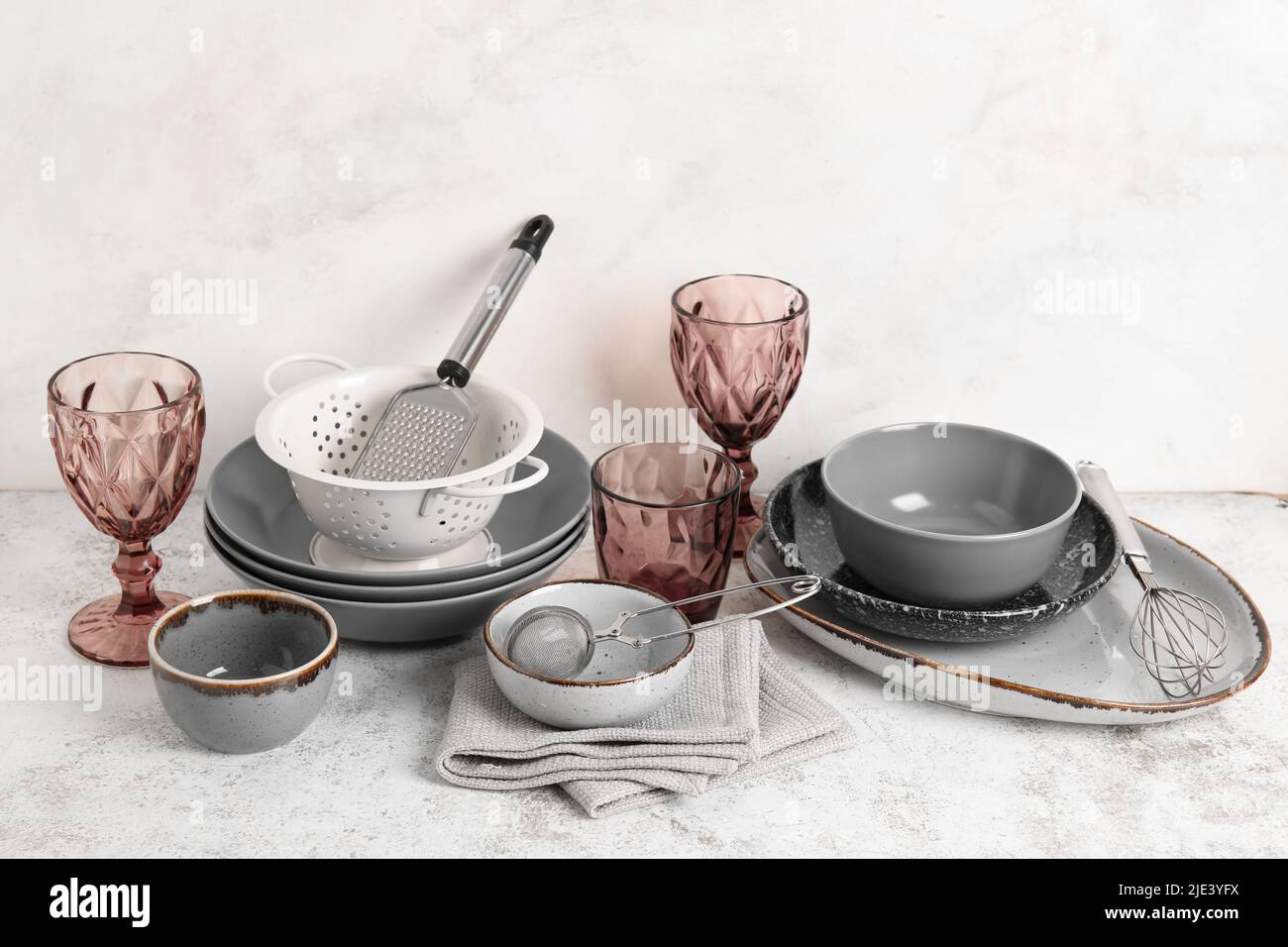 Set of clean dinnerware and kitchen utensils on light background Stock ...