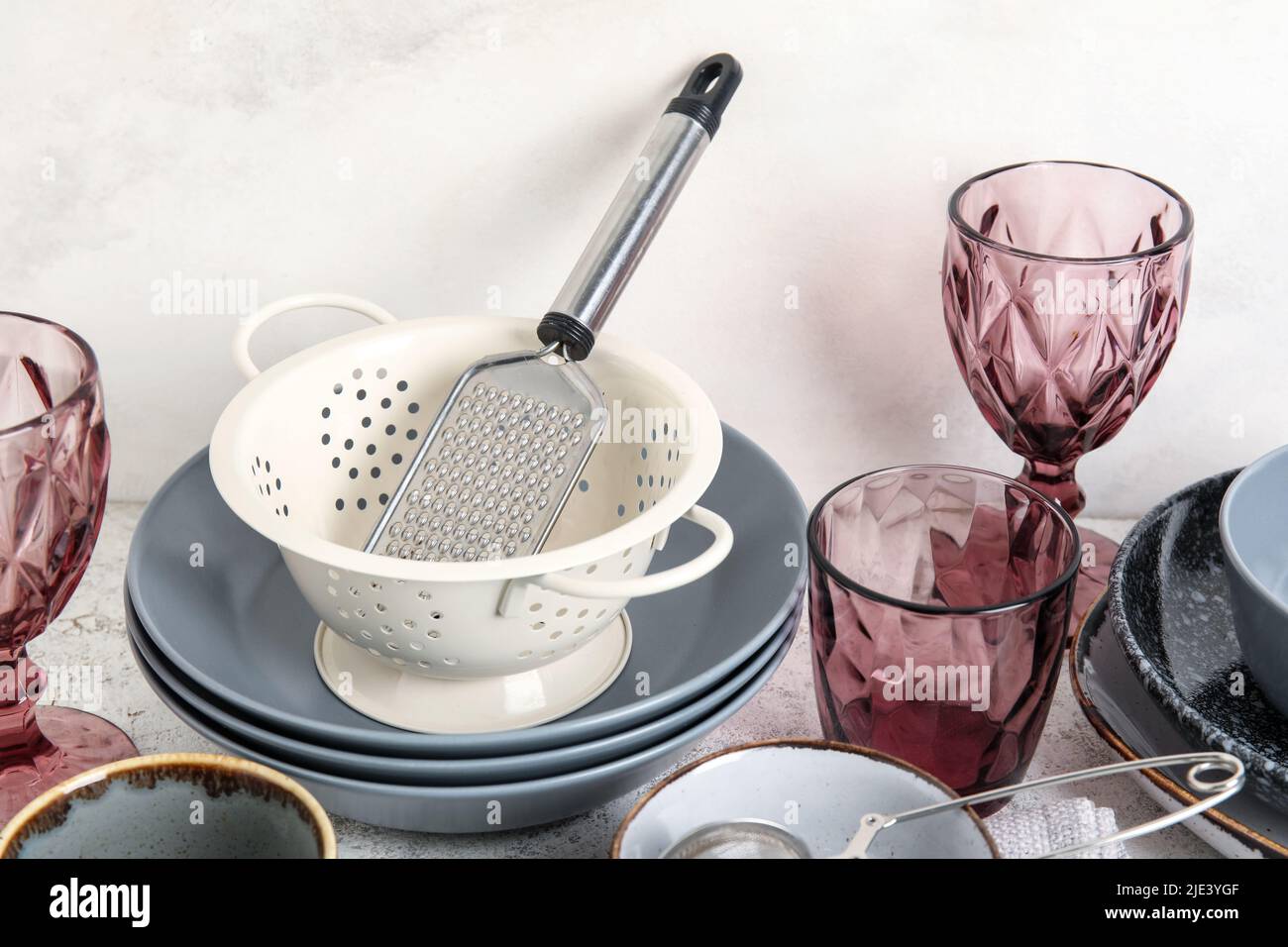 Set of clean dinnerware and kitchen utensils on light background ...