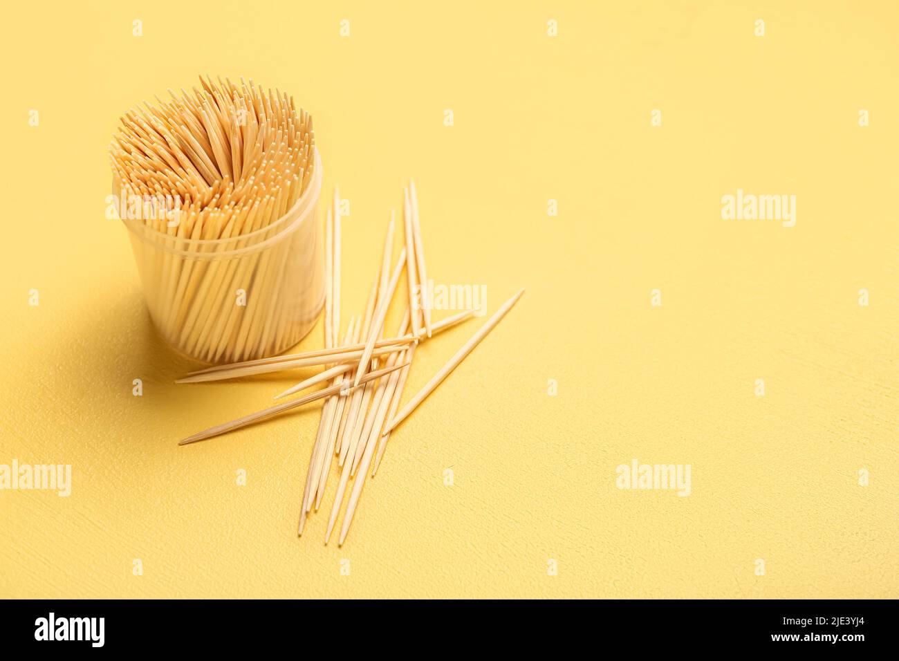 Holder with toothpicks on yellow background Stock Photo - Alamy