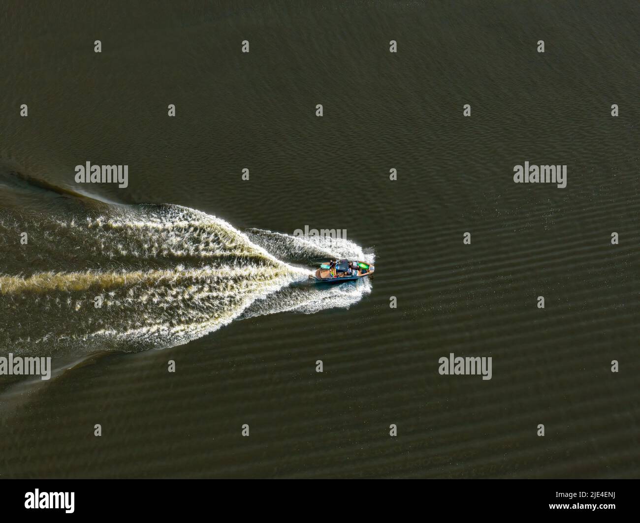 Motor boat floats on the dark water of the lake, aerial view. Aerial ...