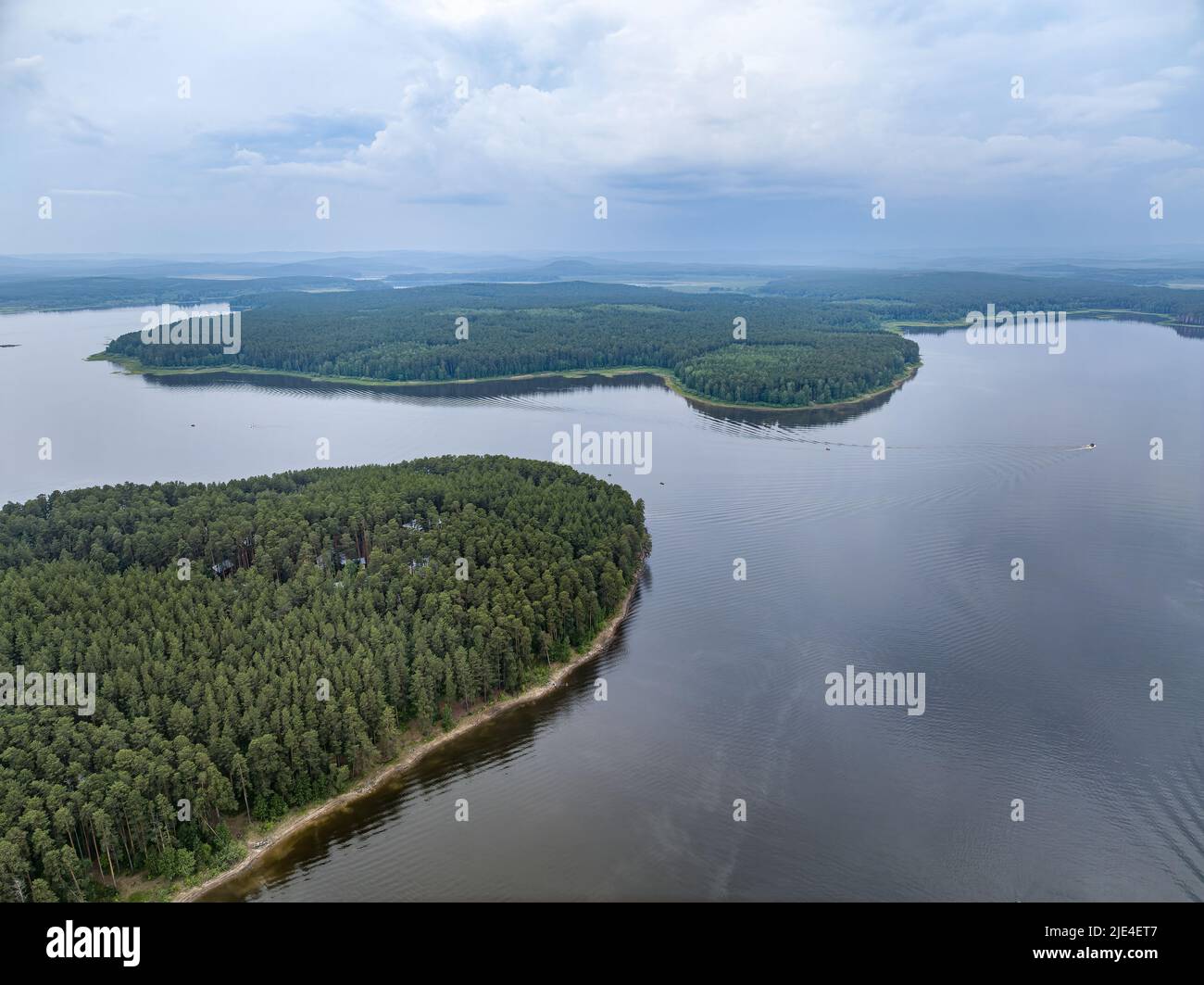 Big lake with green shores in bright sun light, aerial landscape ...