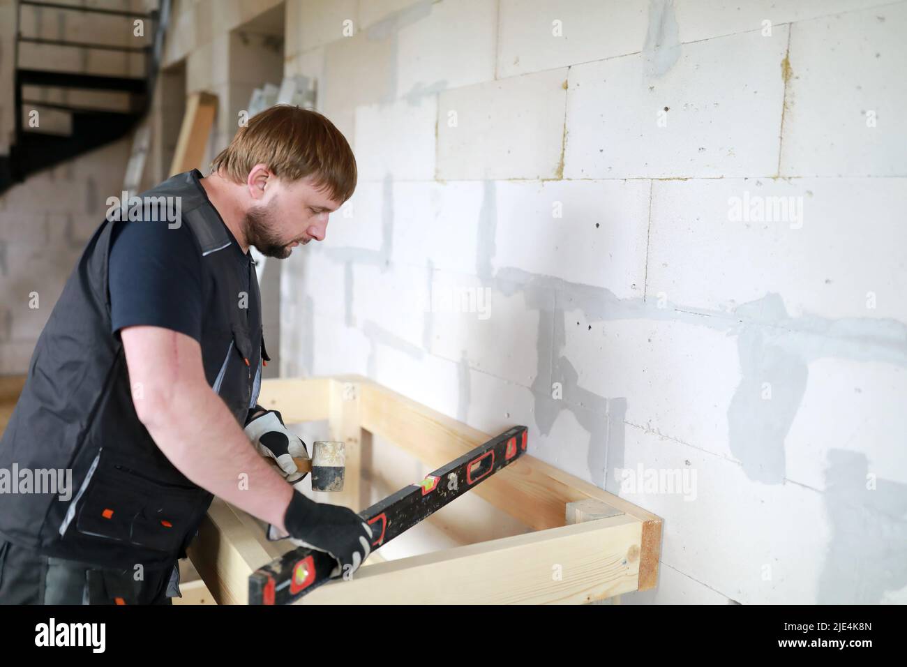 Man using level to assess levelness of table Stock Photo - Alamy