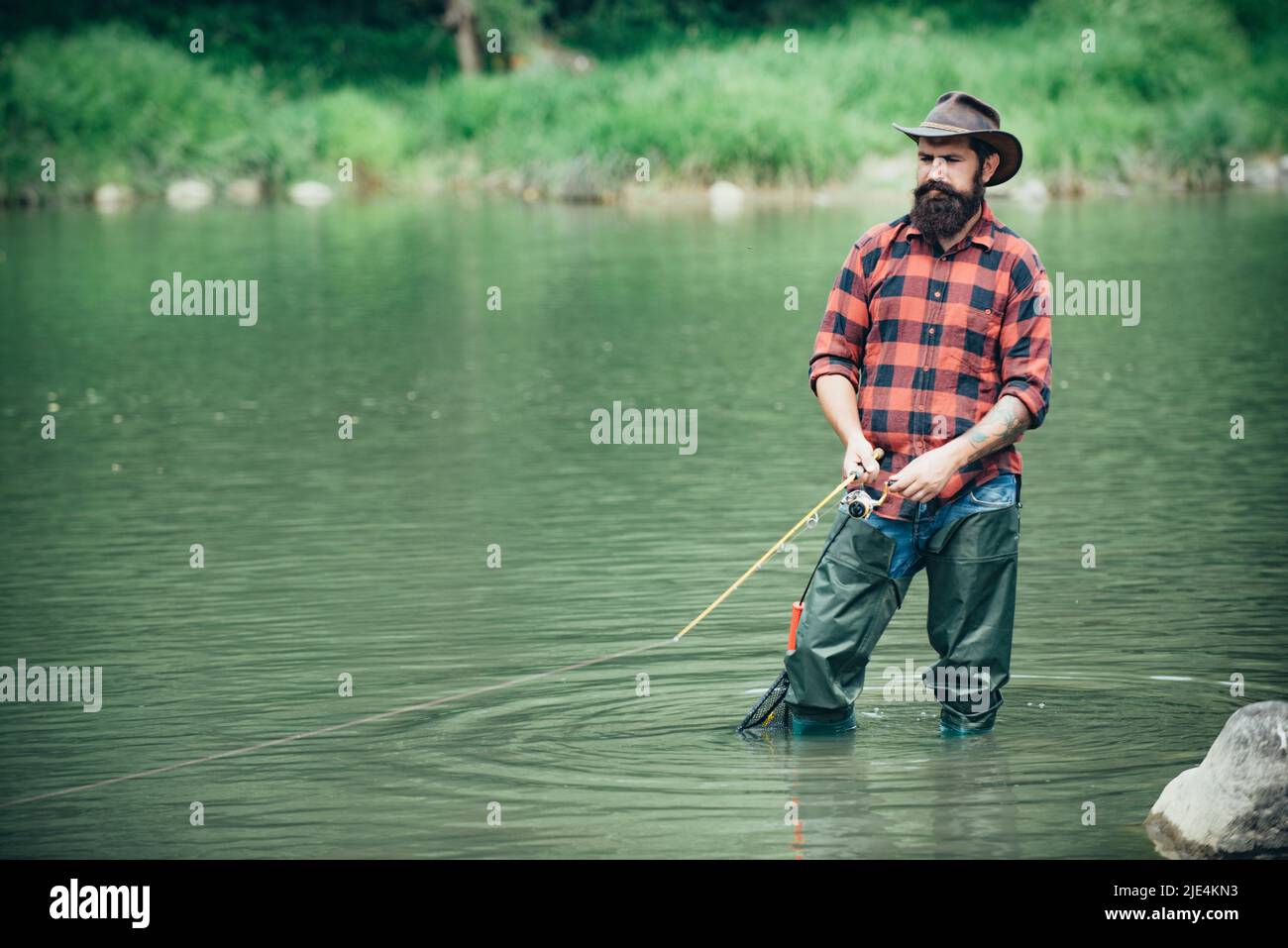 Fisherman caught a fish. Man fishing on river Stock Photo - Alamy