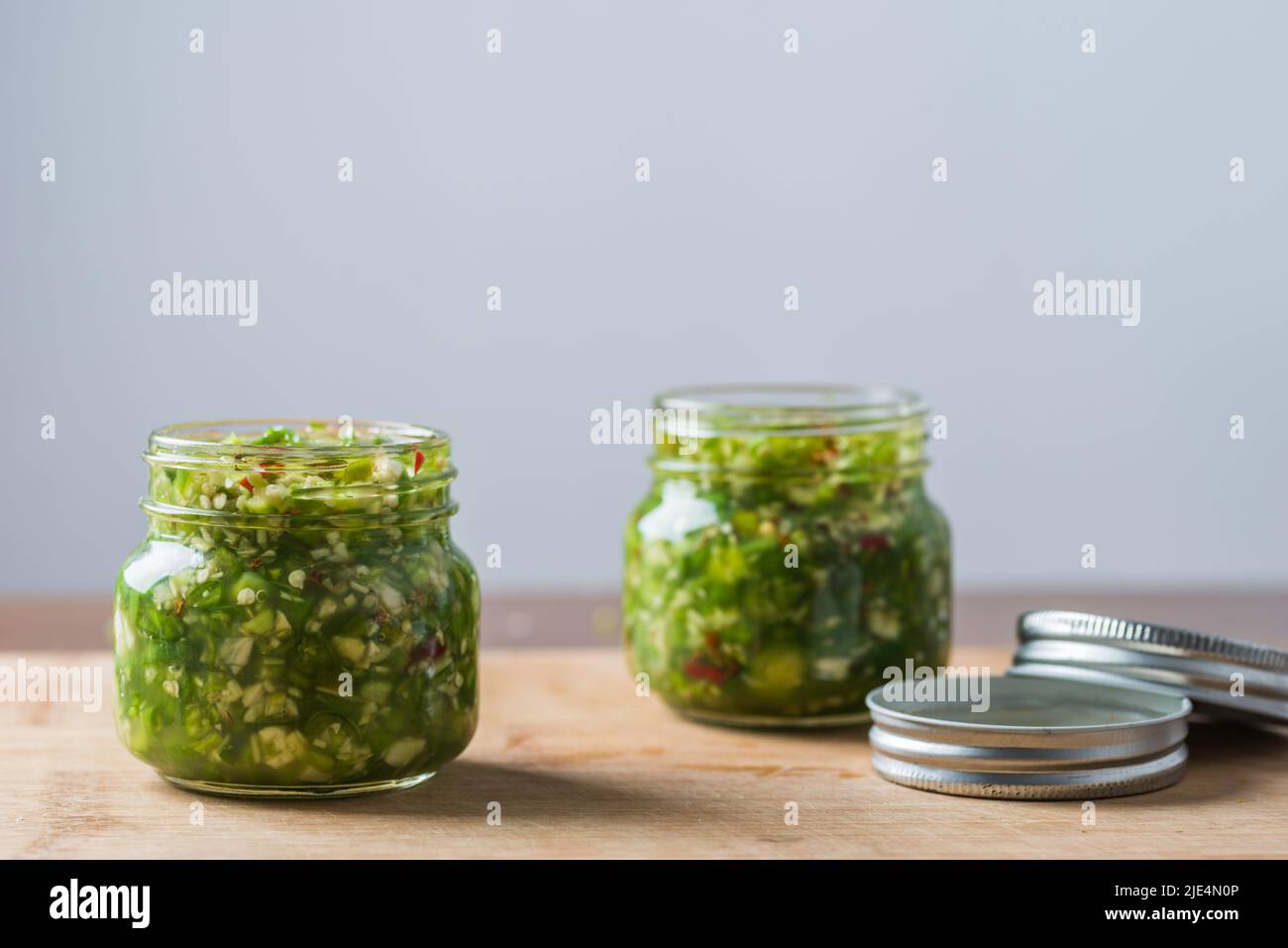 Glass bottles of manual magnificent green chilli sauce Stock Photo - Alamy