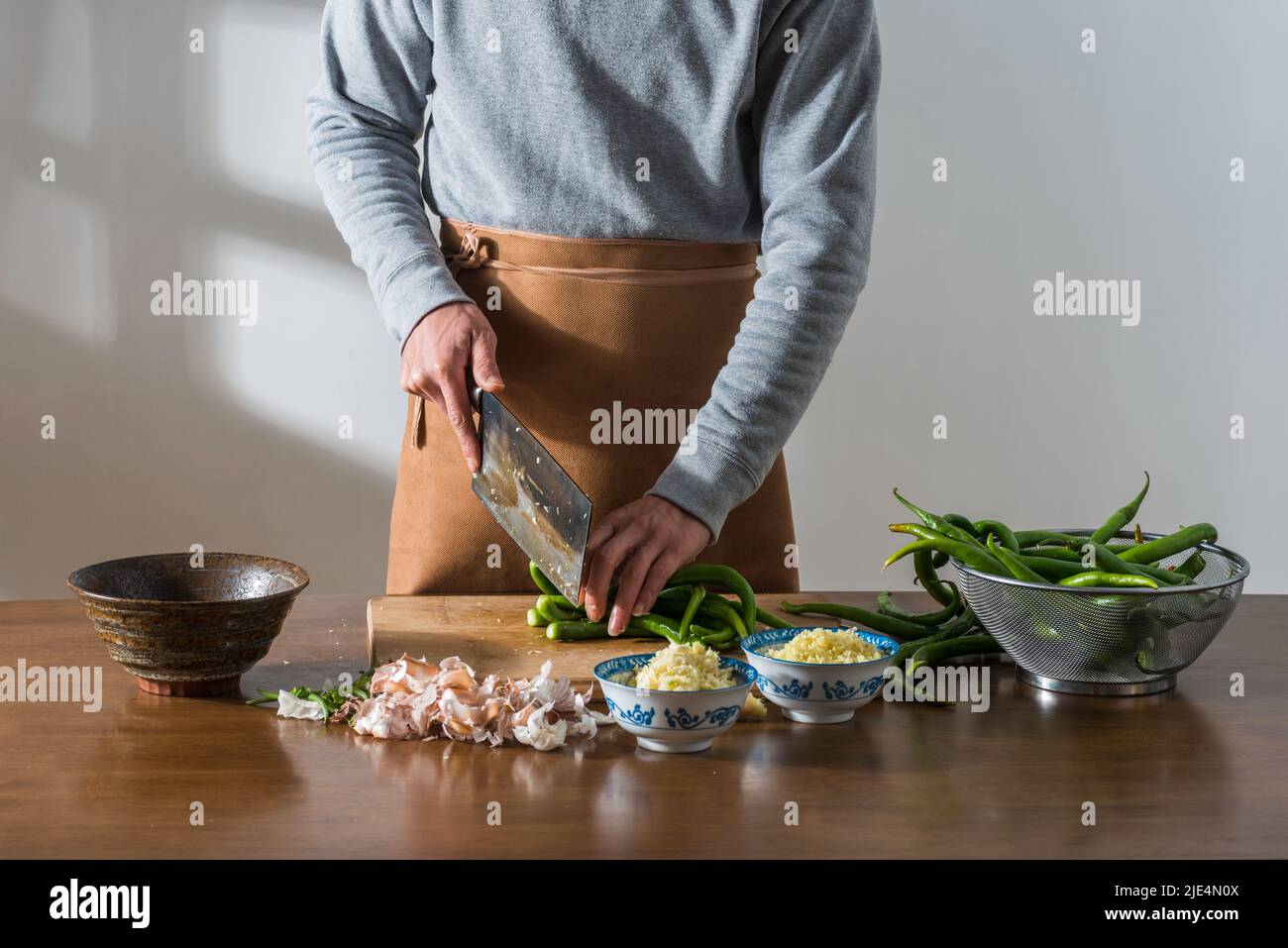 Chef take a kitchen knife cut hang pepper on board Stock Photo - Alamy