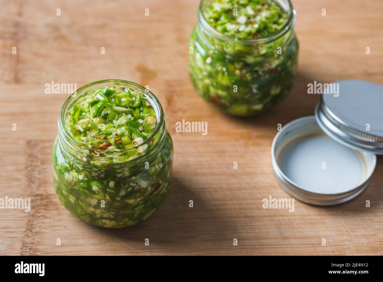 Glass bottles of manual magnificent green chilli sauce Stock Photo - Alamy