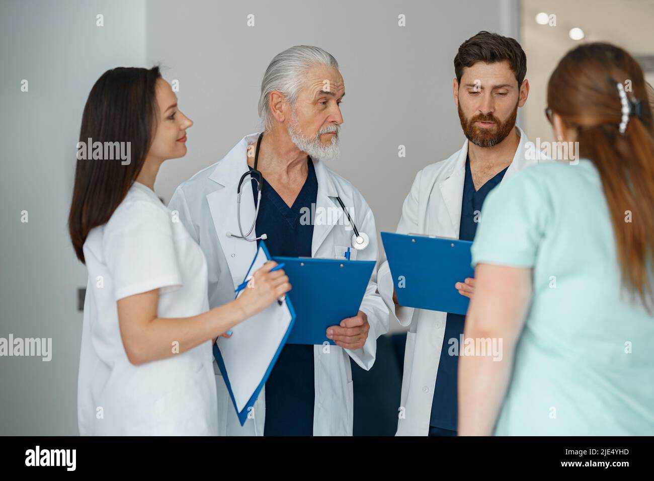 Group of doctor colleagues discussing patient diagnosis stand in clinic ...