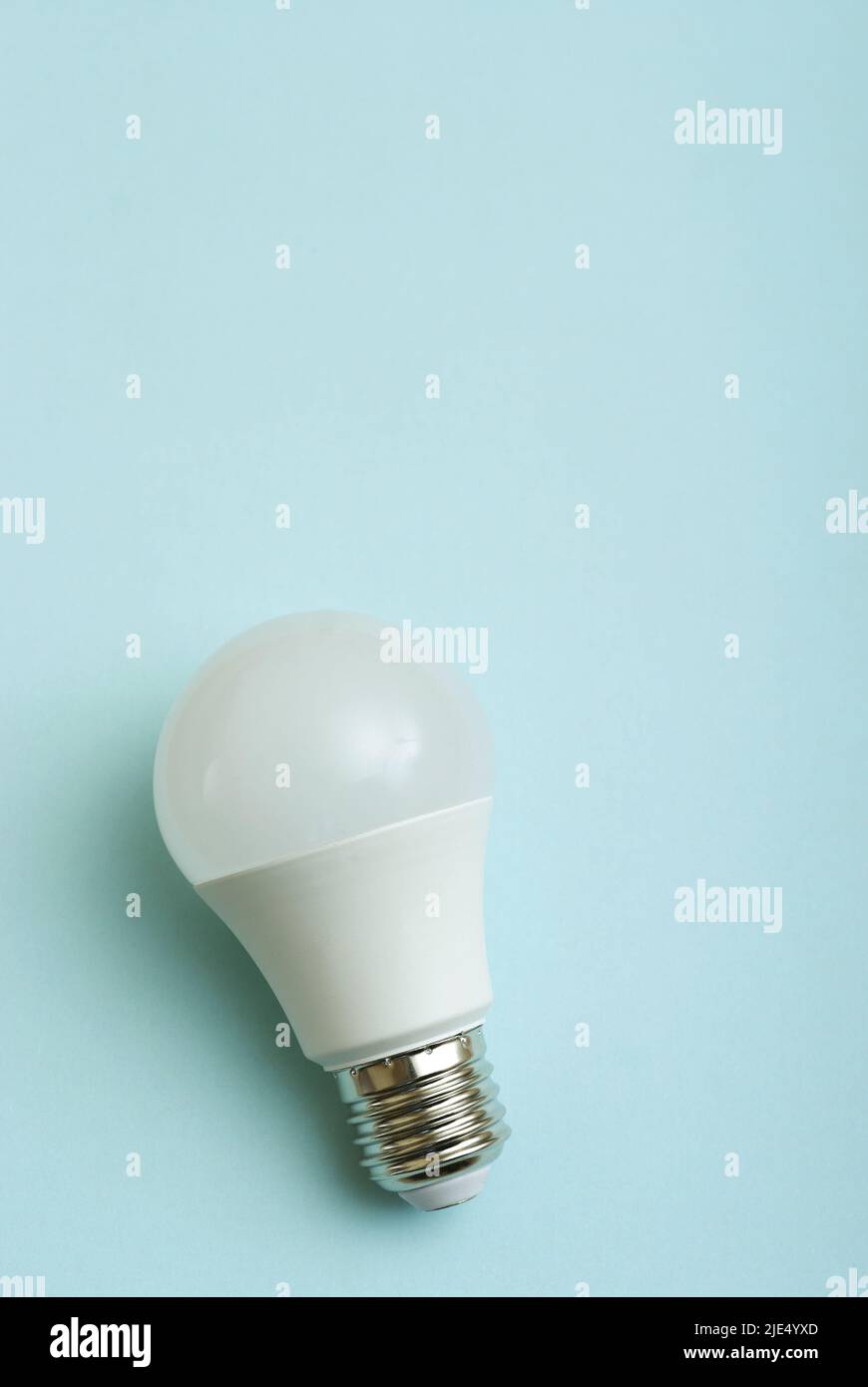 White economy light bulb on blue background with free copy paste space ...