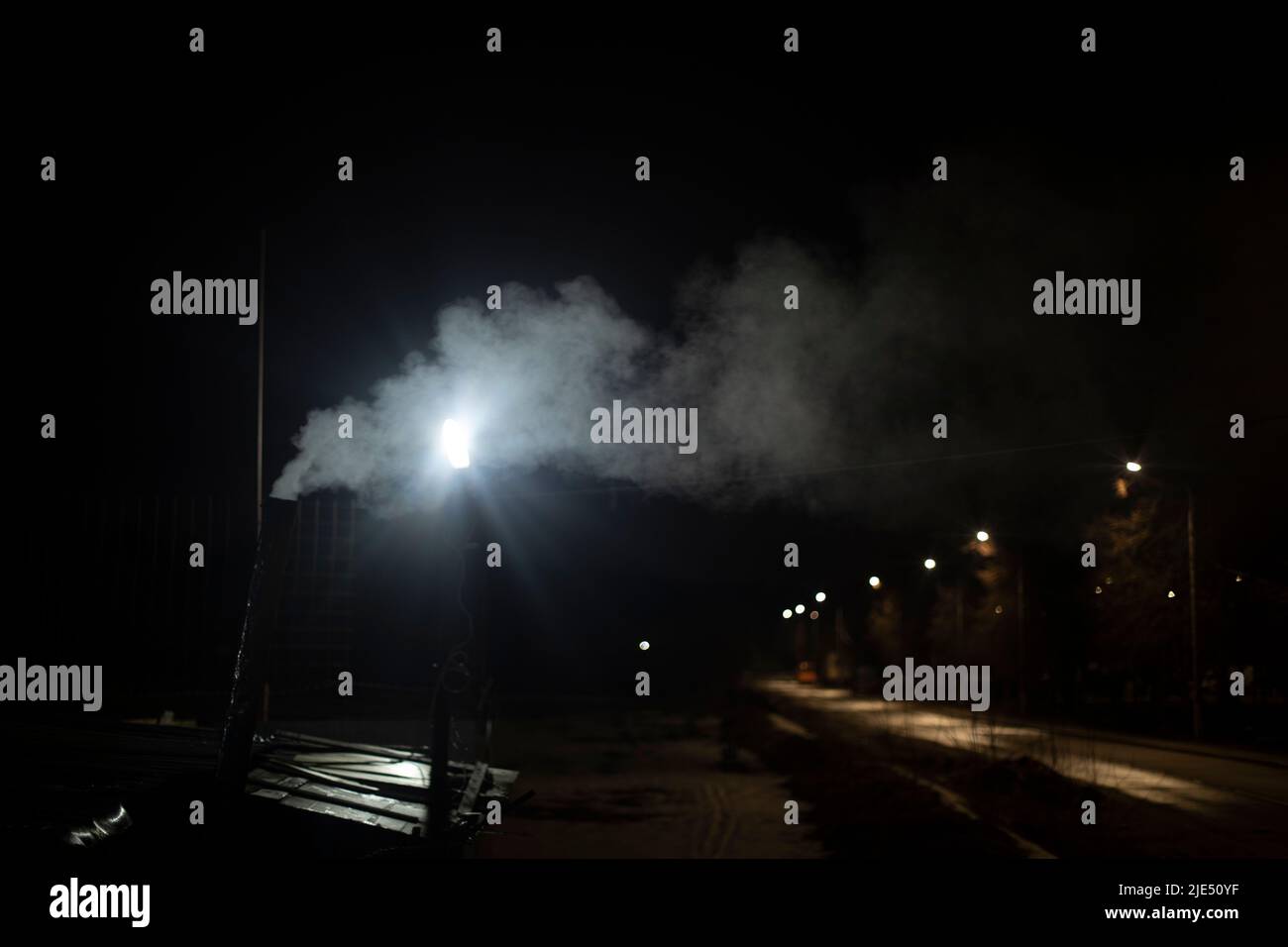 Smoke at night. Smoke in spotlight. Road and smoke from chimney Stock ...