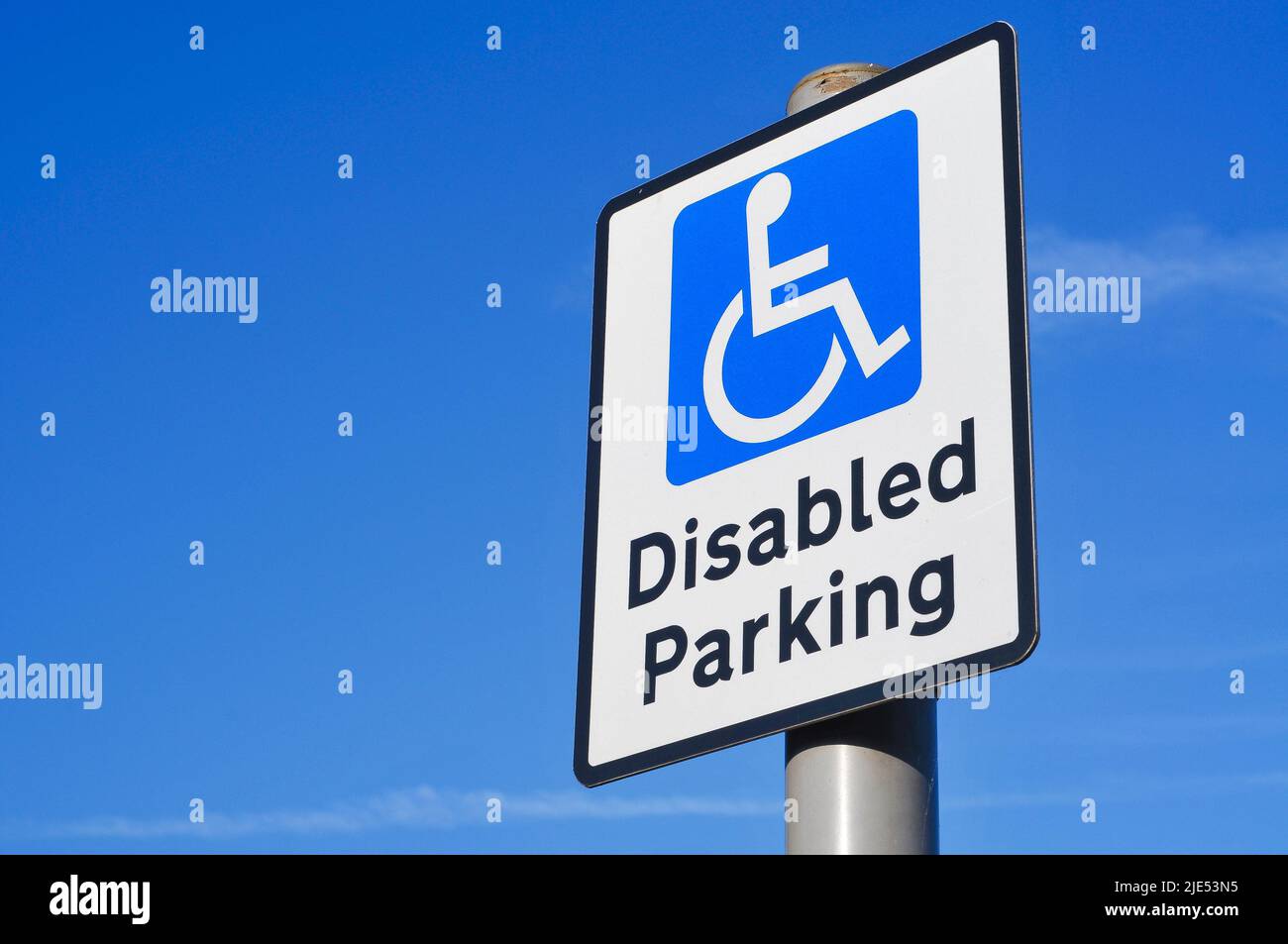 Disabled parking space sign against a clear blue sky Stock Photo - Alamy